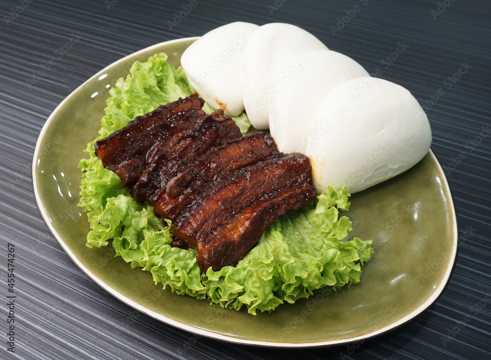 braised pork belly meat wrapped with mantou bun Chinese burger in plate ...