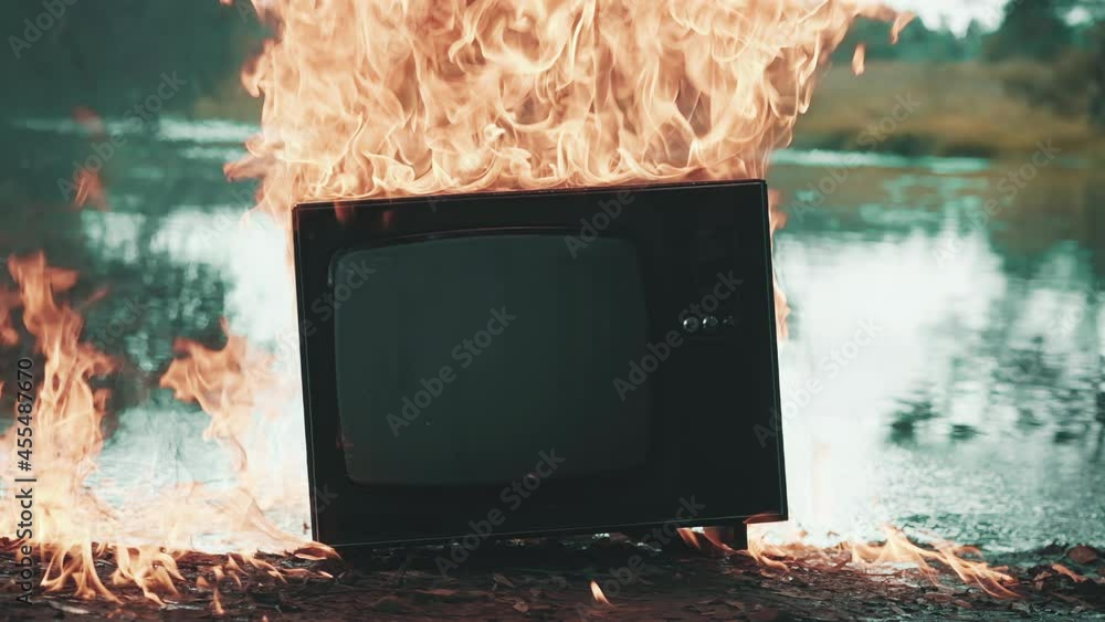 Vidéo Stock Old vintage TV stands on ground and burns with fire. Behind ...