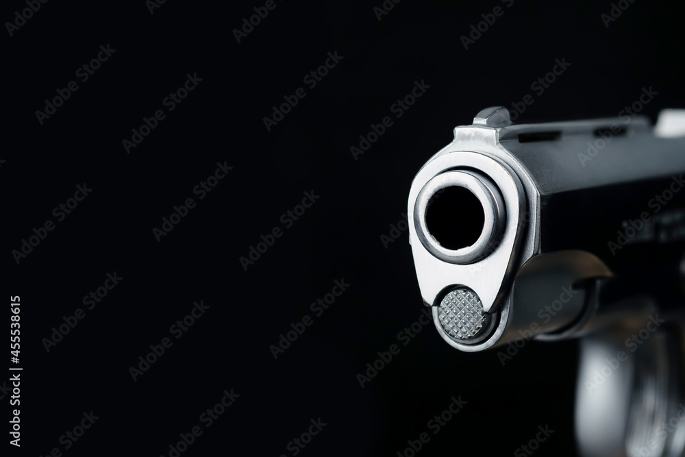 The muzzle part of the pistol scene on a black background represents a ...