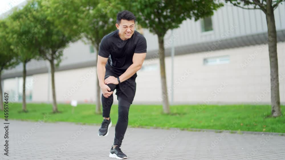 young asian runner athlete with muscle pain. Man massaging Stretching ...