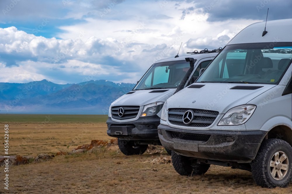 4x4 camper van with mountains and cloudy blue sky background. Mersedes ...