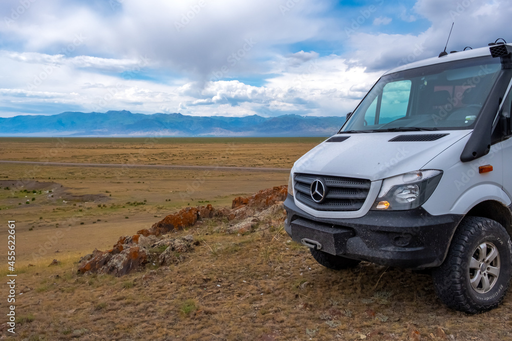 4x4 camper van with mountains and cloudy blue sky background. Mersedes ...