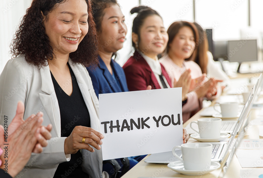 Group of businesswomen sitting at working desk, clapping hands and show ...
