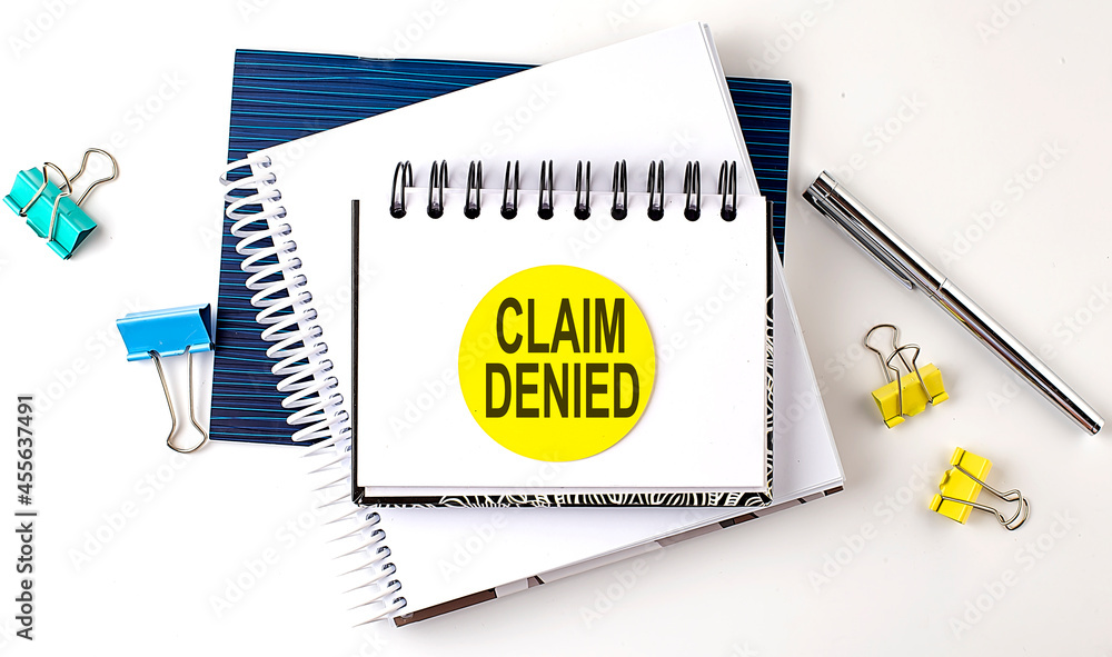 Sticker with CLAIM DENIED text on notebooks on the white background ...