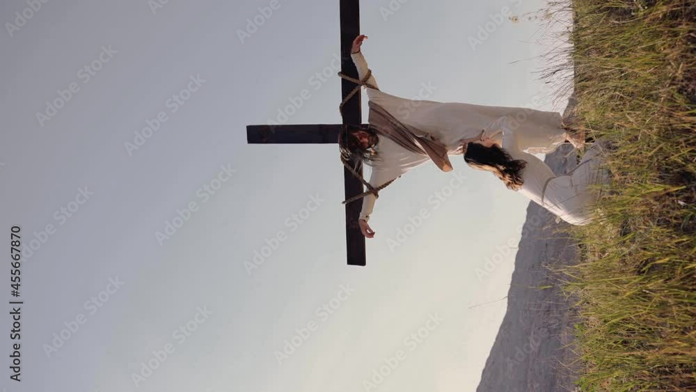Mary mourns the death of Jesus at his feet. Jesus is crucified on the cross. Wind is blowing ...