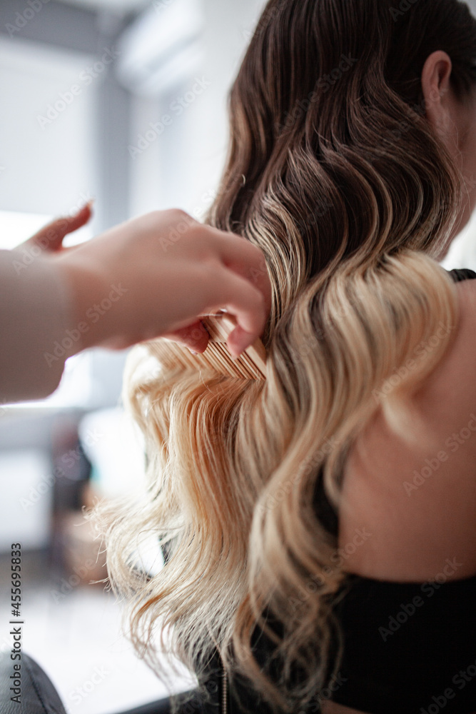 Foto de stylist hairdresser makes a hairstyle for a girl in his beauty ...