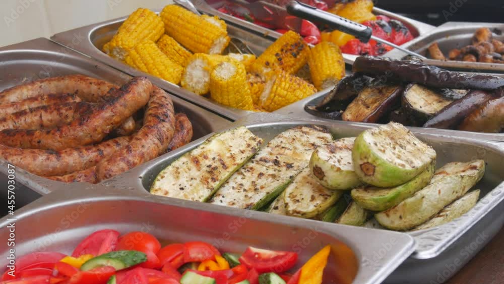 Grilled corn, sausage, eggplant and zucchini counter at outdoor street ...