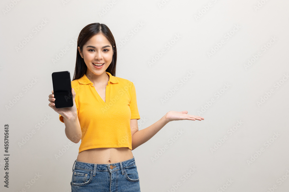 Pretty young asian woman showing screen of smartphone and palm up hand ...