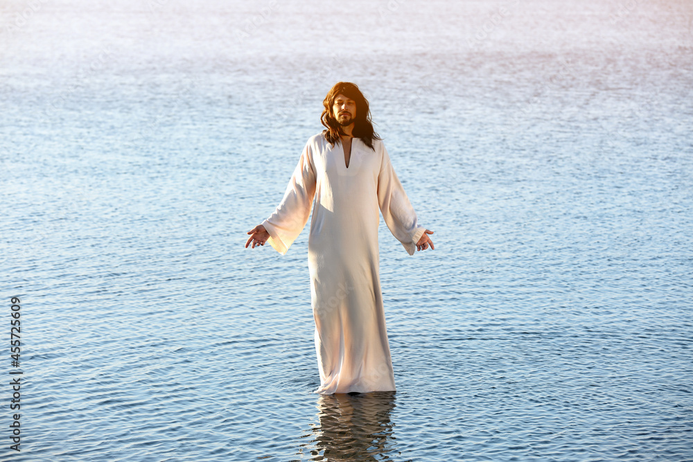Jesus Christ in water lit by morning sun Stock Photo | Adobe Stock