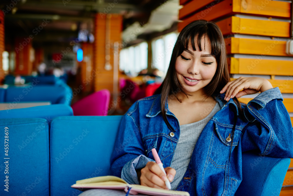 Asian female student with education textbook doing homework test making ...
