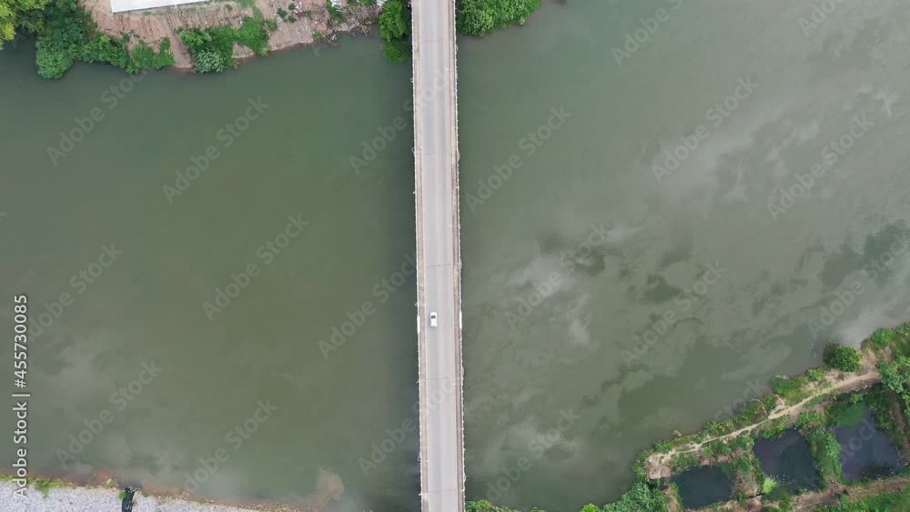 Cross bridge on river with oil stain and waste discharge from factory ...