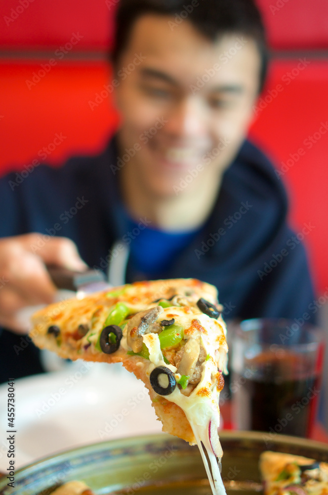 Blurred man holding pizza slice Stock Photo | Adobe Stock