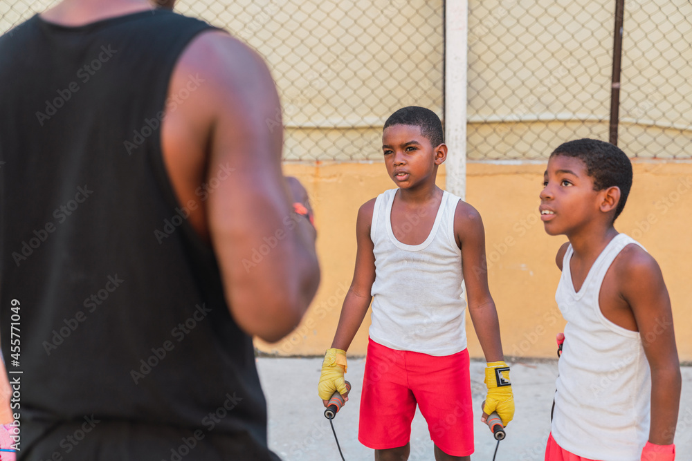 Coach and young boxers in a boxing school. Stock Photo | Adobe Stock