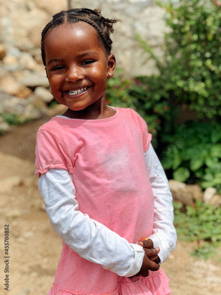 Cute little african girl looking at camera smiling while standing ...