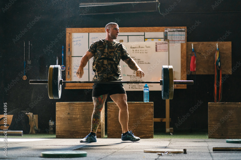 Muscular sportsman dropping barbell on floor Stock Photo | Adobe Stock