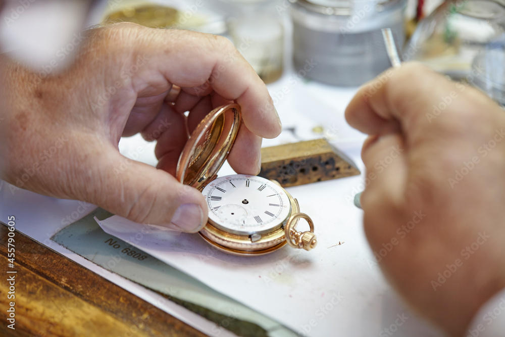 Mature Watchmaker repairing vintage pocket watch and clock on the ...