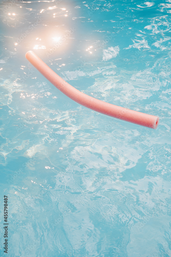 Pink Pool Noodle Floating in a Shimmering Pool Stock Photo | Adobe Stock