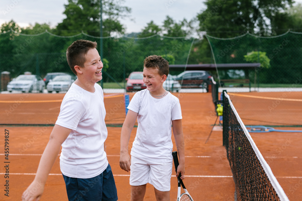 Tennis academy. Young kids playing tennis on the outdoor court. Stock ...