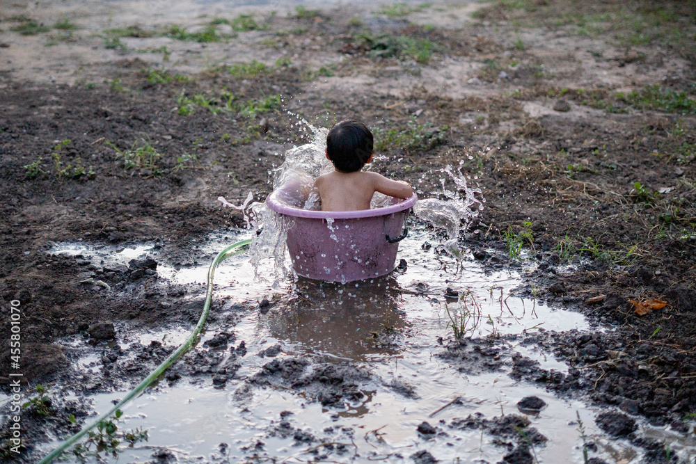 Boy taking a bath in a plastic basin Stock Photo | Adobe Stock
