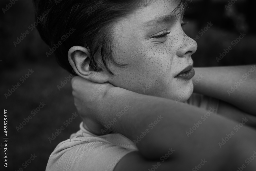 Freckled boy touching neck Stock Photo | Adobe Stock