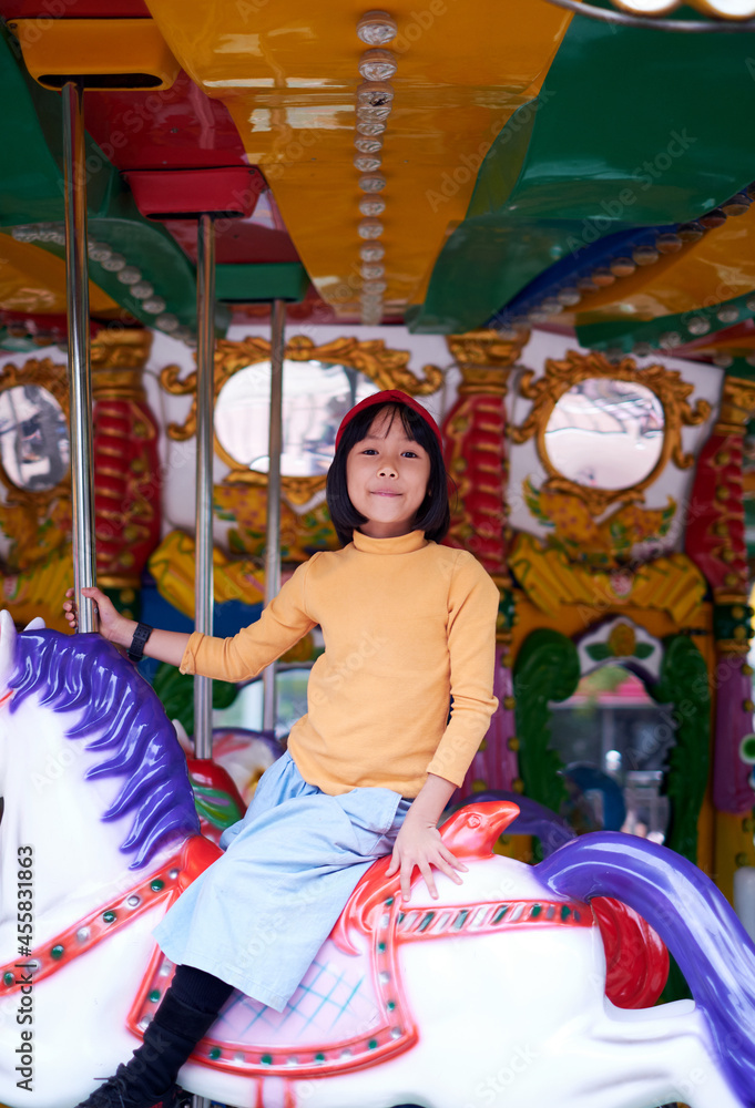 Asian girl sitting on the Carousel Stock Photo | Adobe Stock