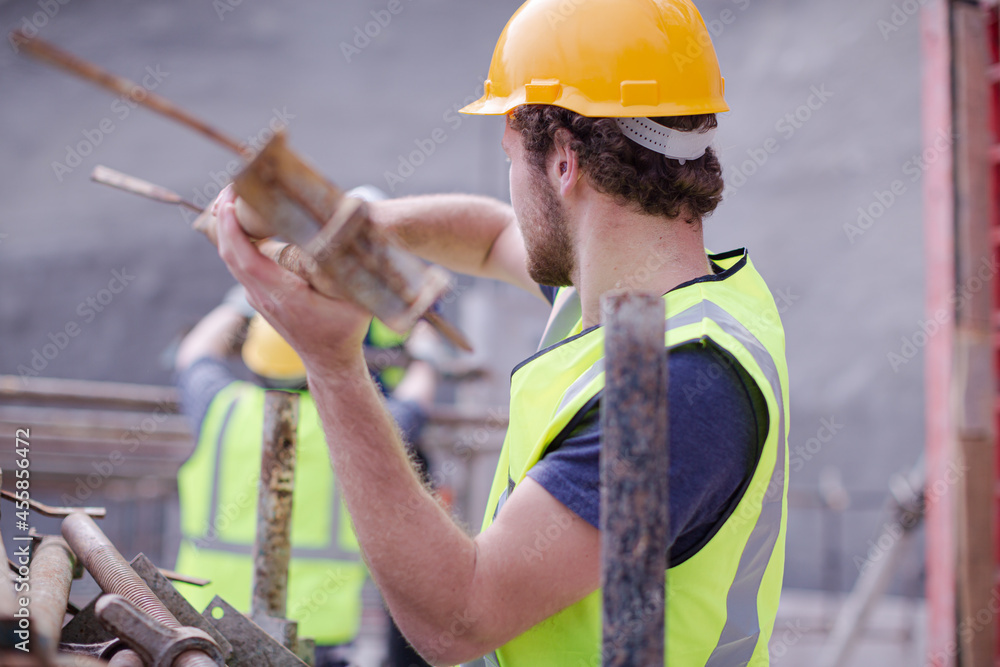 Constructor workers assembling rebar structure at construction site ...