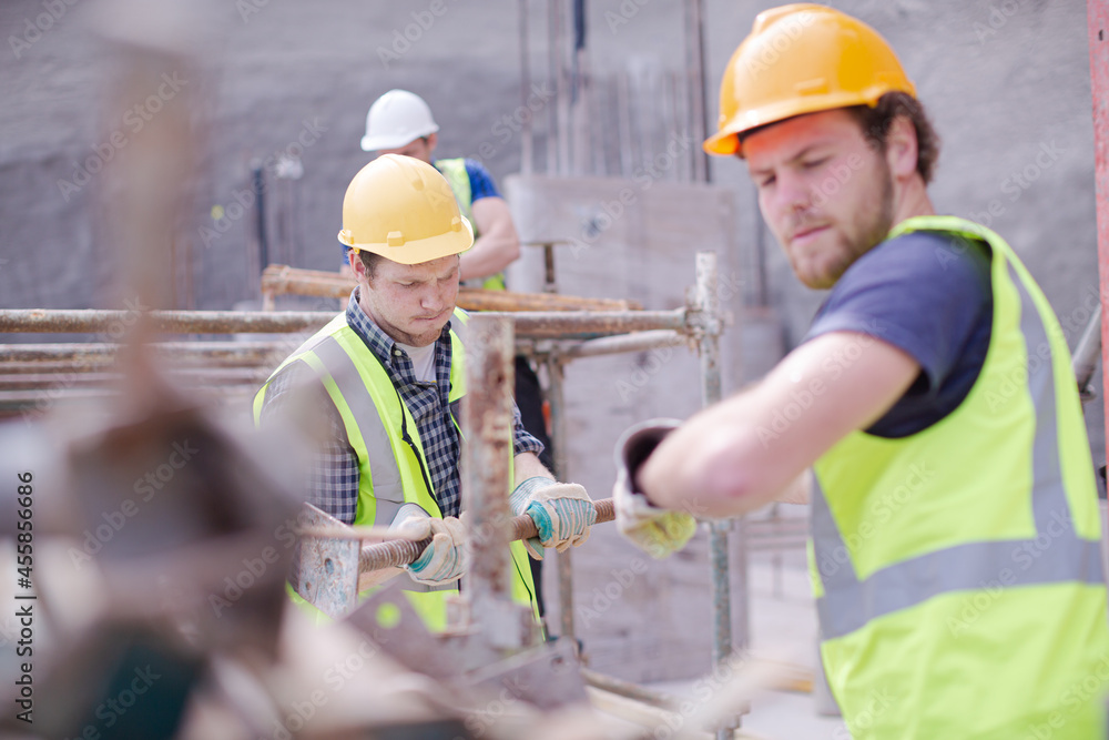 Constructor workers assembling rebar structure at construction site ...