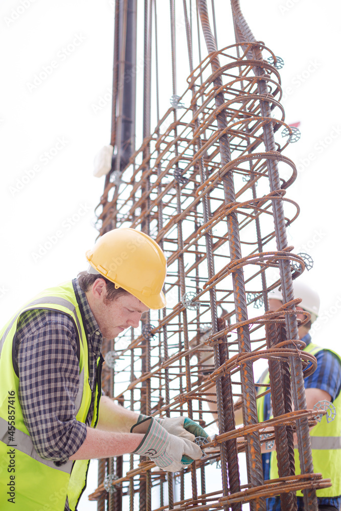 Constructor workers assembling rebar structure at construction site ...