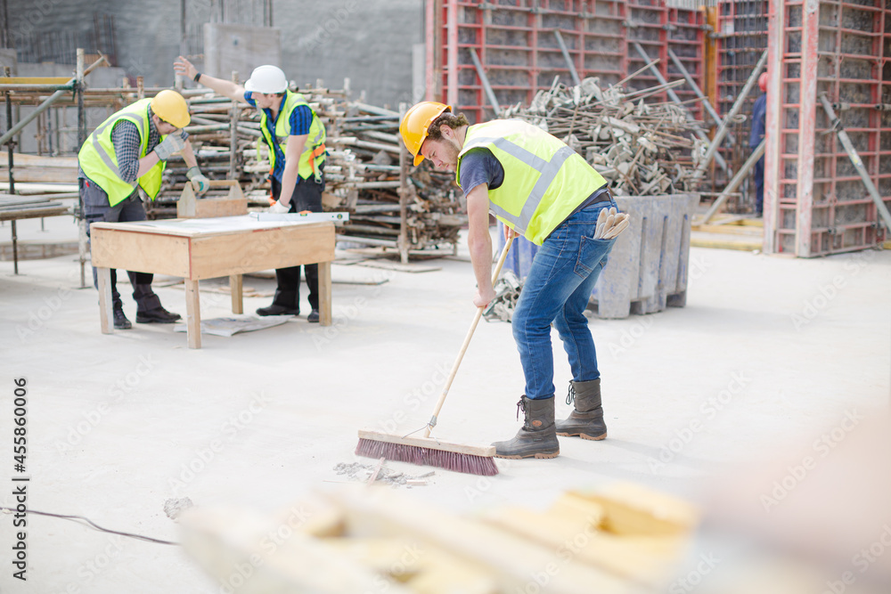 Construction worker sweeping at construction site Stock Photo | Adobe Stock