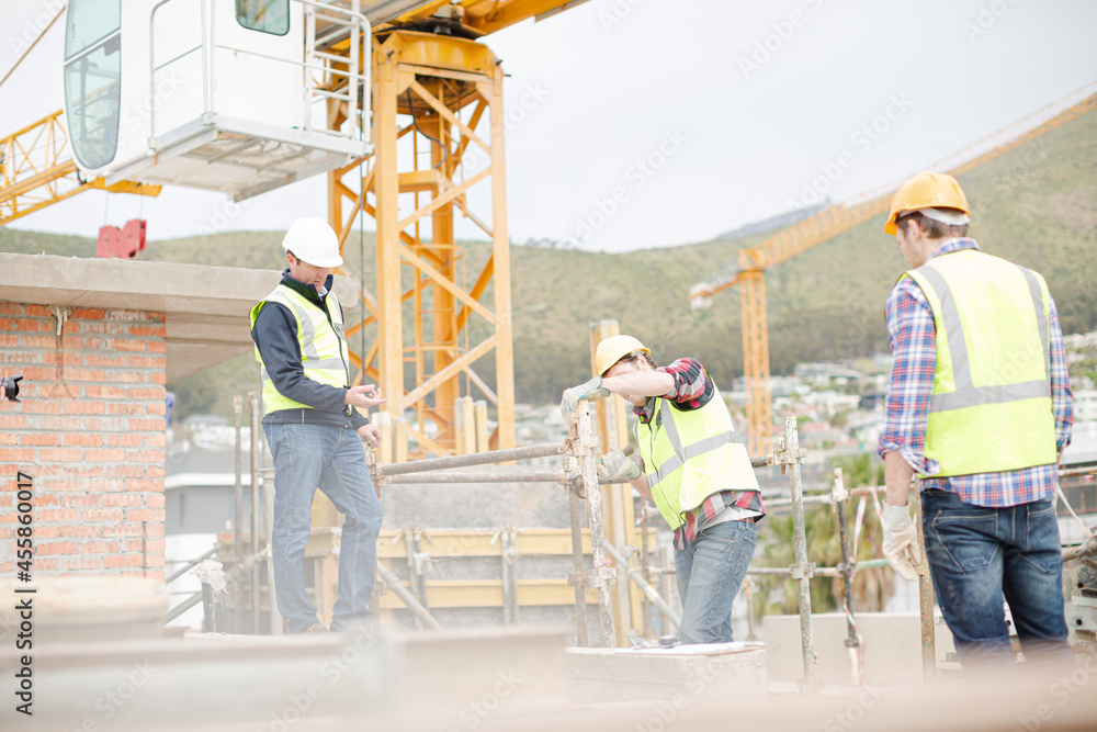 Constructor workers assembling rebar structure at construction site ...