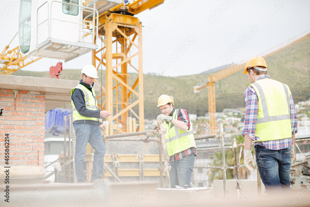Constructor workers assembling rebar structure at construction site ...