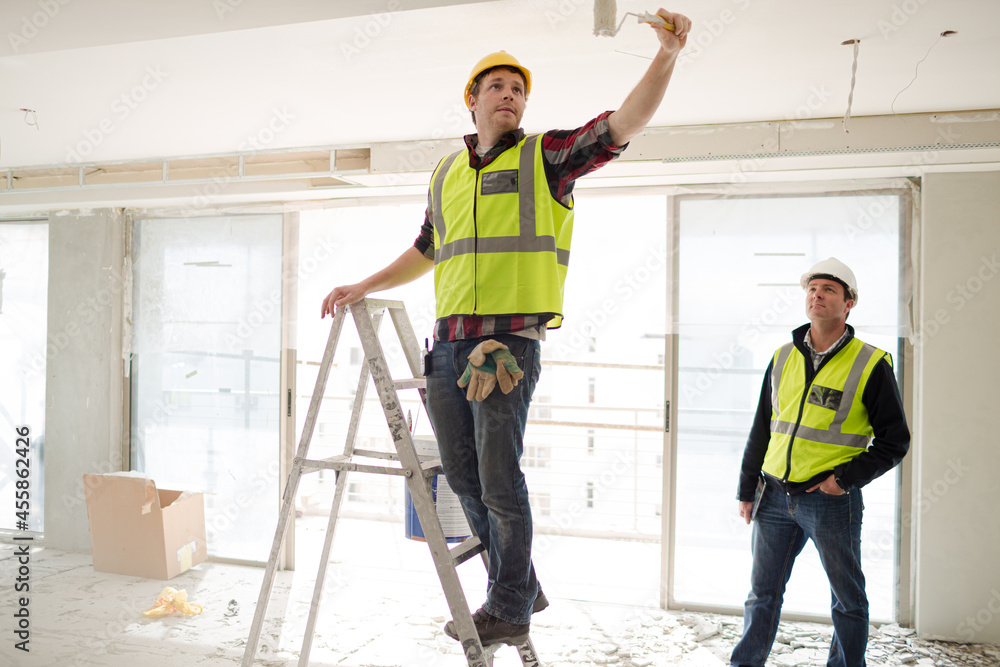 Construction worker on ladder at construction site Stock Photo | Adobe ...
