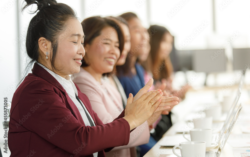 Group of businesswomen in suit sitting at working desk and clapping ...