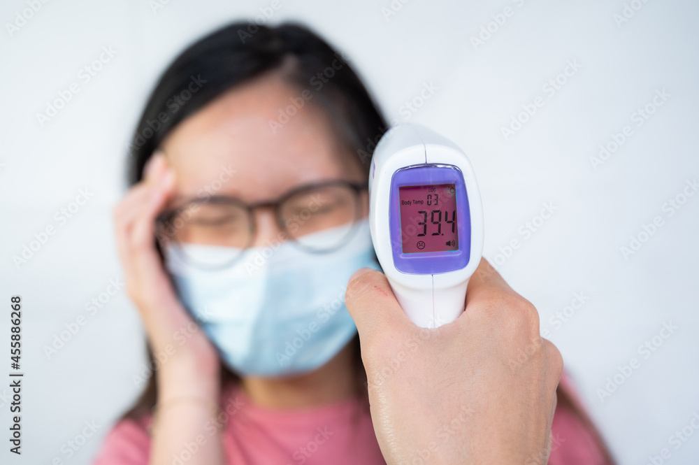 Someone hand using infrared thermometer gun to measuring woman ...