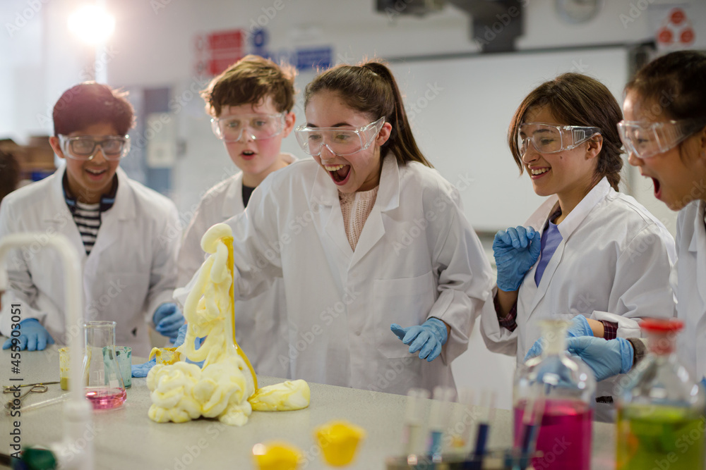 Surprised students conducting exploding foam scientific experiment in ...