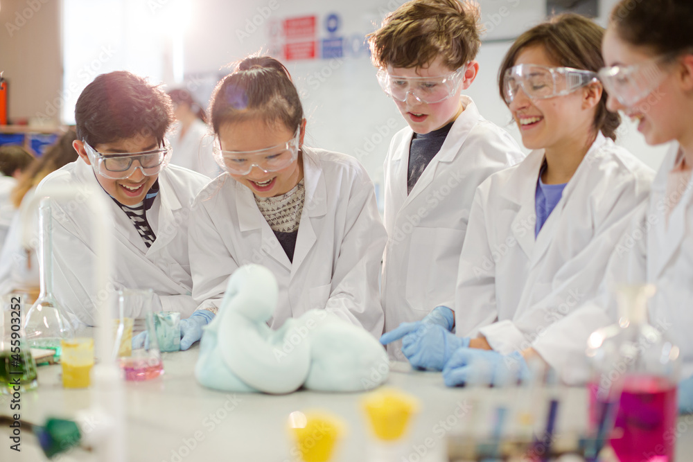 Surprised students conducting exploding foam scientific experiment in ...