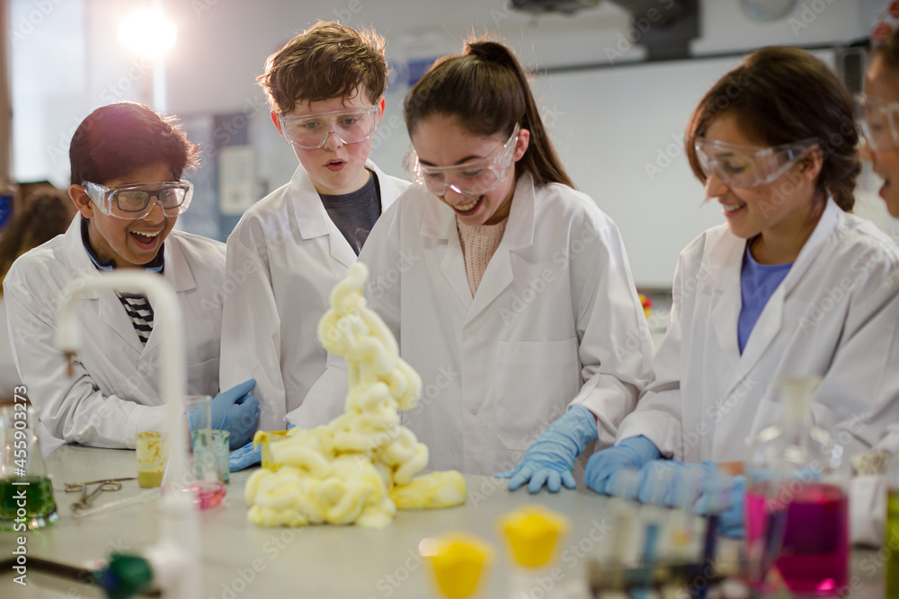 Surprised students conducting exploding foam scientific experiment in ...