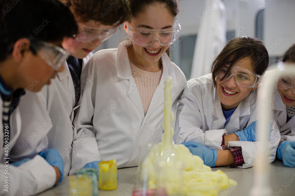Surprised students conducting exploding foam scientific experiment in ...