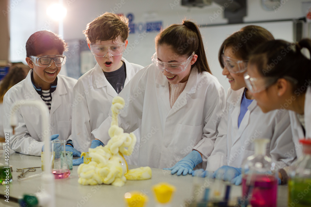 Surprised students conducting exploding foam scientific experiment in ...