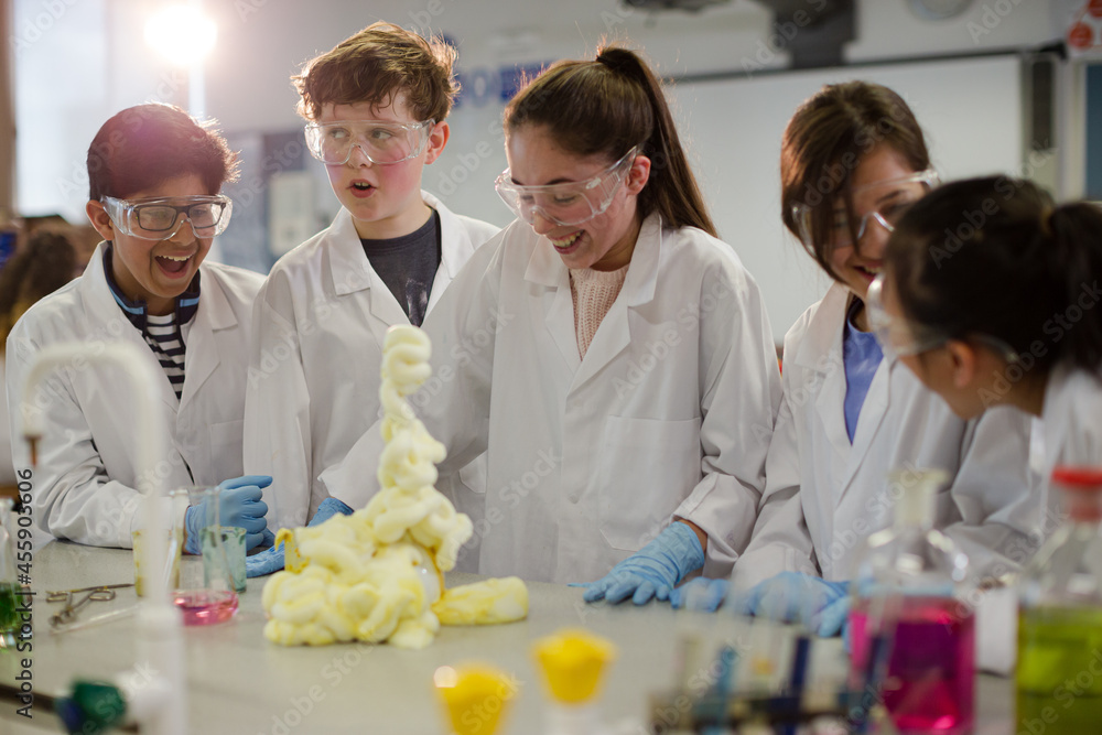 Surprised students conducting exploding foam scientific experiment in ...