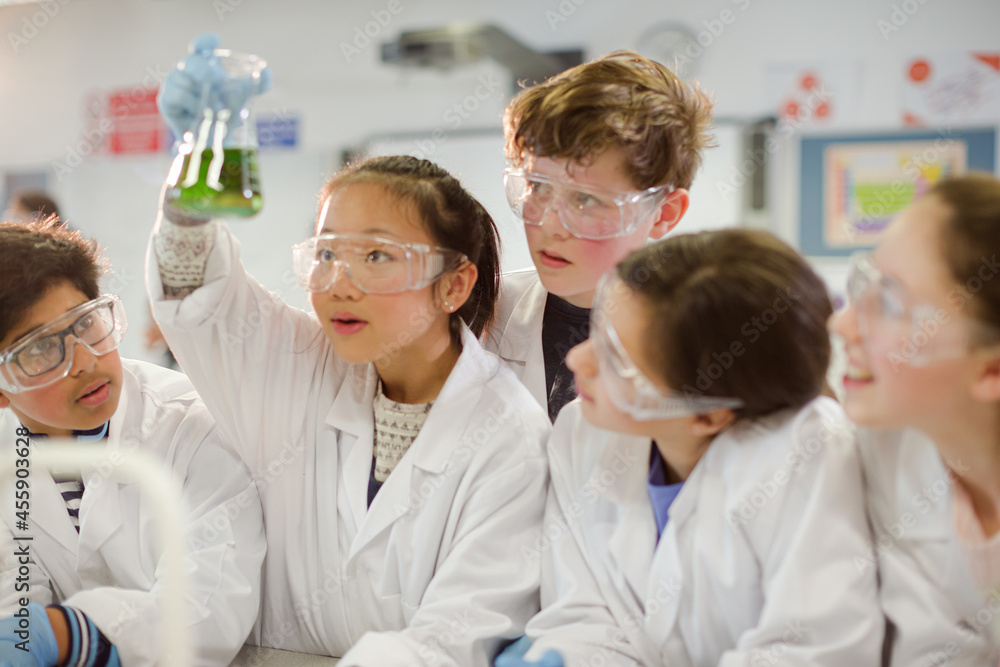 Curious students conducting scientific experiment, examining liquid in ...