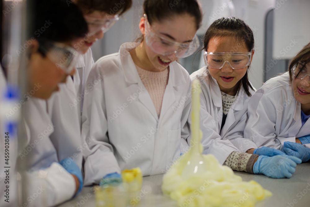 Surprised students conducting exploding foam scientific experiment in ...