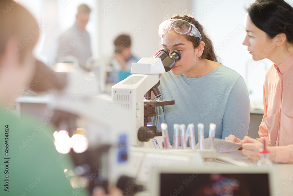 Female teacher and girl student conducting scientific experiment at ...