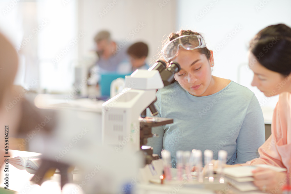 Female teacher and girl student conducting scientific experiment at ...