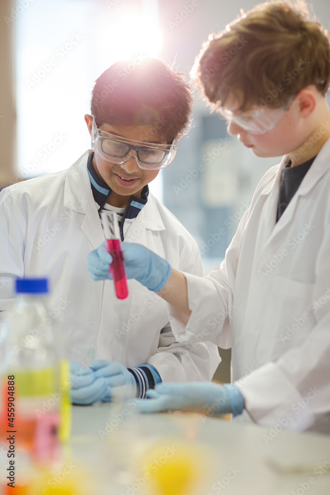 Boy students examining liquid in test tube, conducting scientific ...