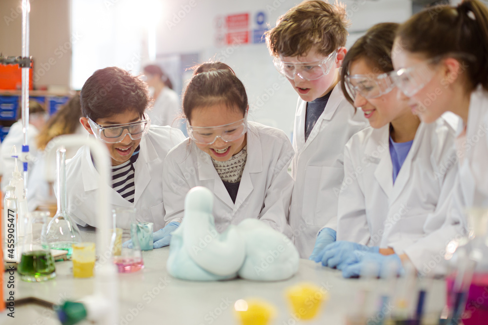 Surprised students conducting exploding foam scientific experiment in ...