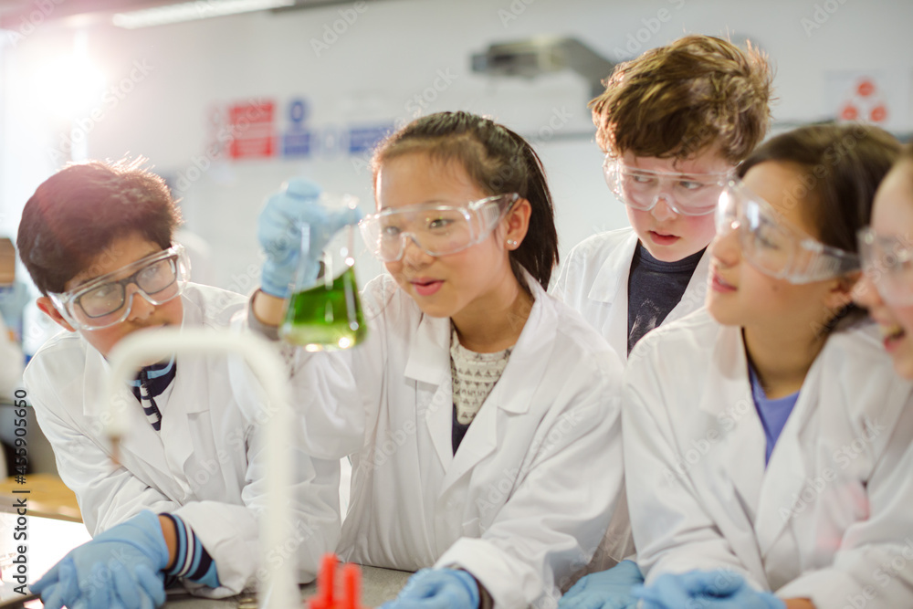 Curious students conducting scientific experiment, examining liquid in ...