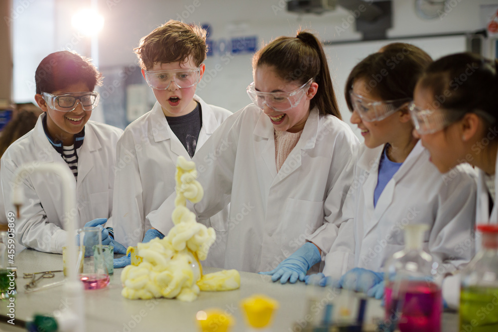 Surprised students conducting exploding foam scientific experiment in ...