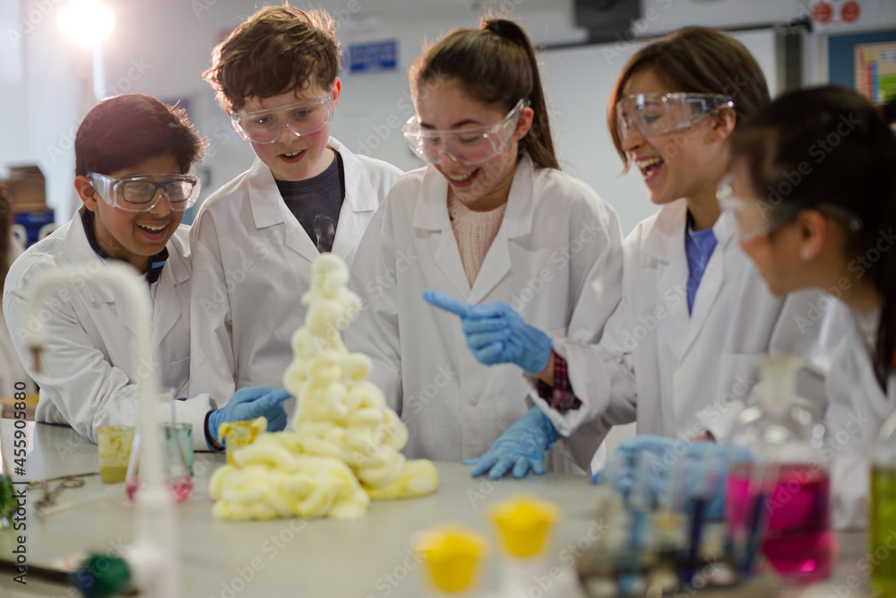 Surprised students conducting exploding foam scientific experiment in ...