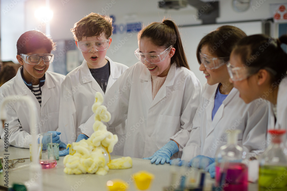 Surprised students conducting exploding foam scientific experiment in ...